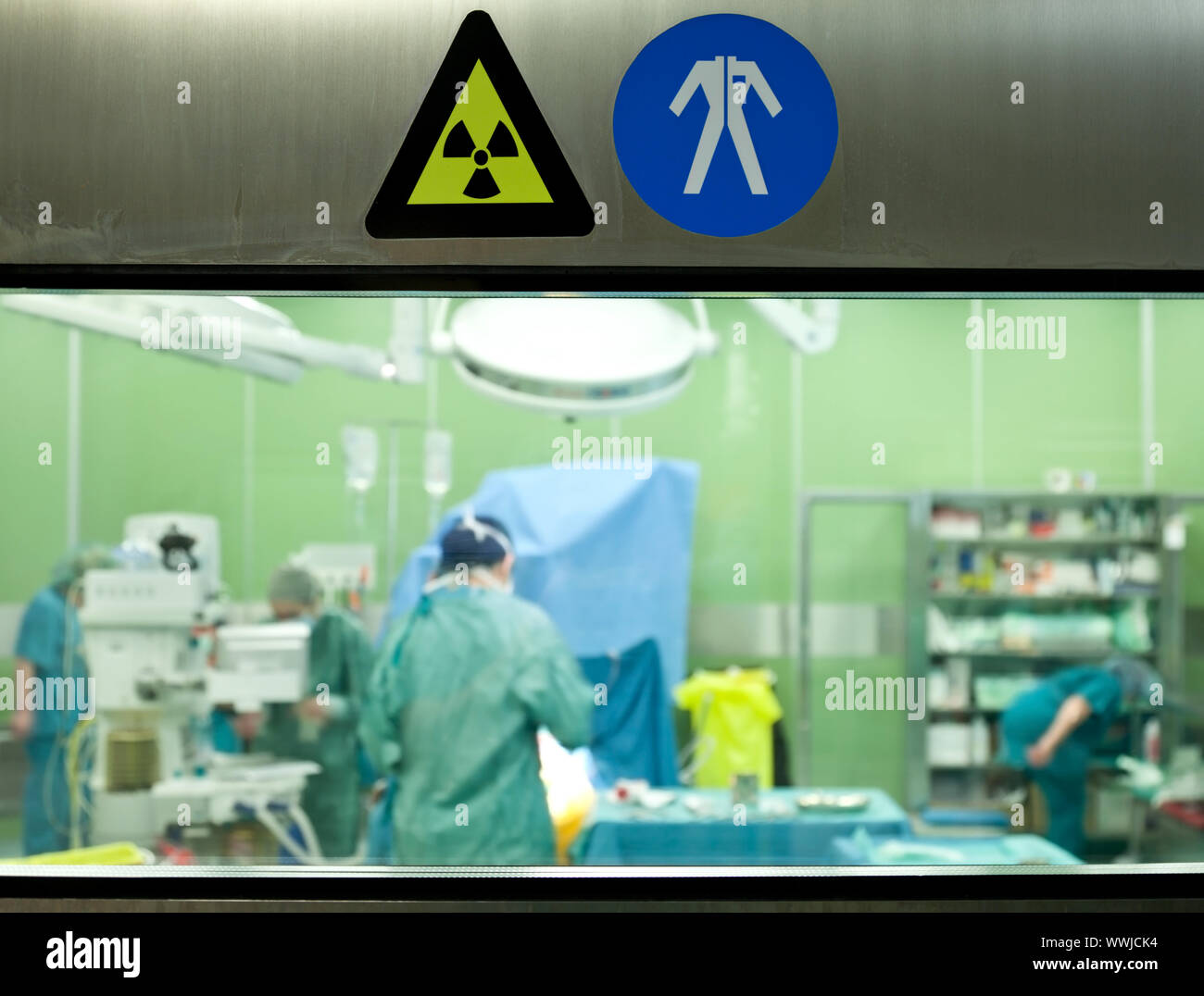 Warning signs on door of operative room with busy doctors Stock Photo ...