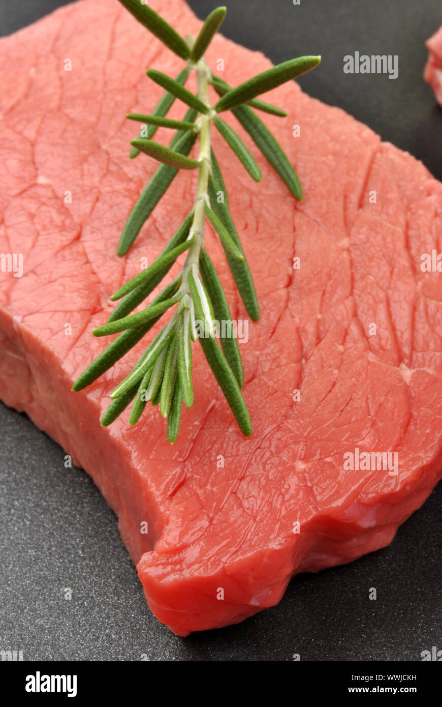 raw organic steak with rosemary in a pan Stock Photo - Alamy