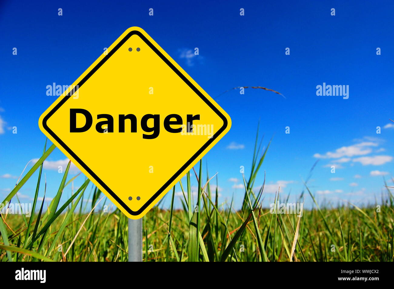 danger written on a yellow road warning sign Stock Photo - Alamy