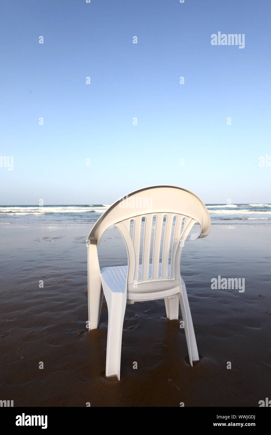 chair on sand and ocean background Stock Photo - Alamy