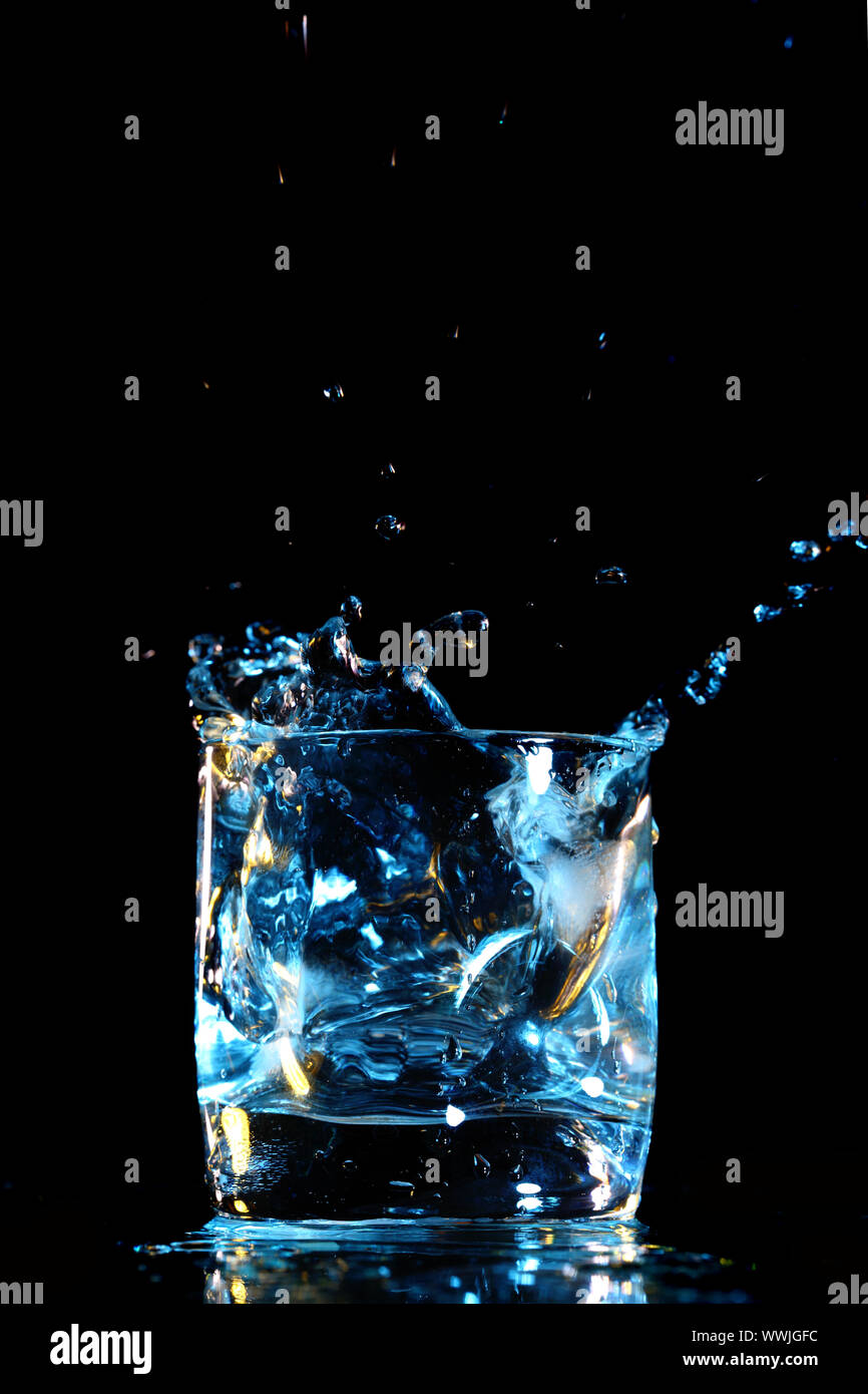 alcohol splash on black background Stock Photo - Alamy