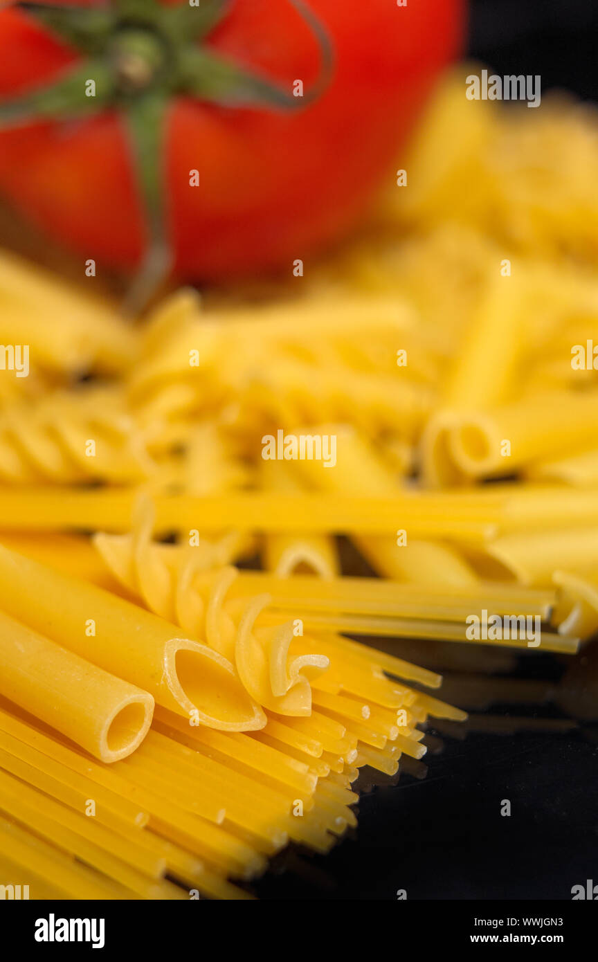 Italian pasta selection with fresh tomato over black closeup DOF Stock ...