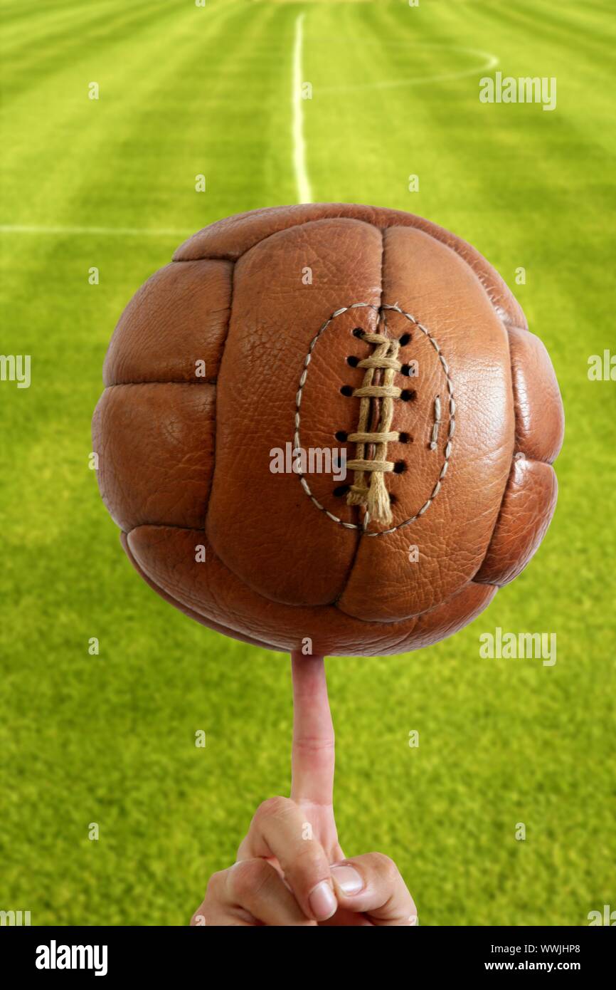 Aged vintage retro football leather ball in man hand grass field Stock ...