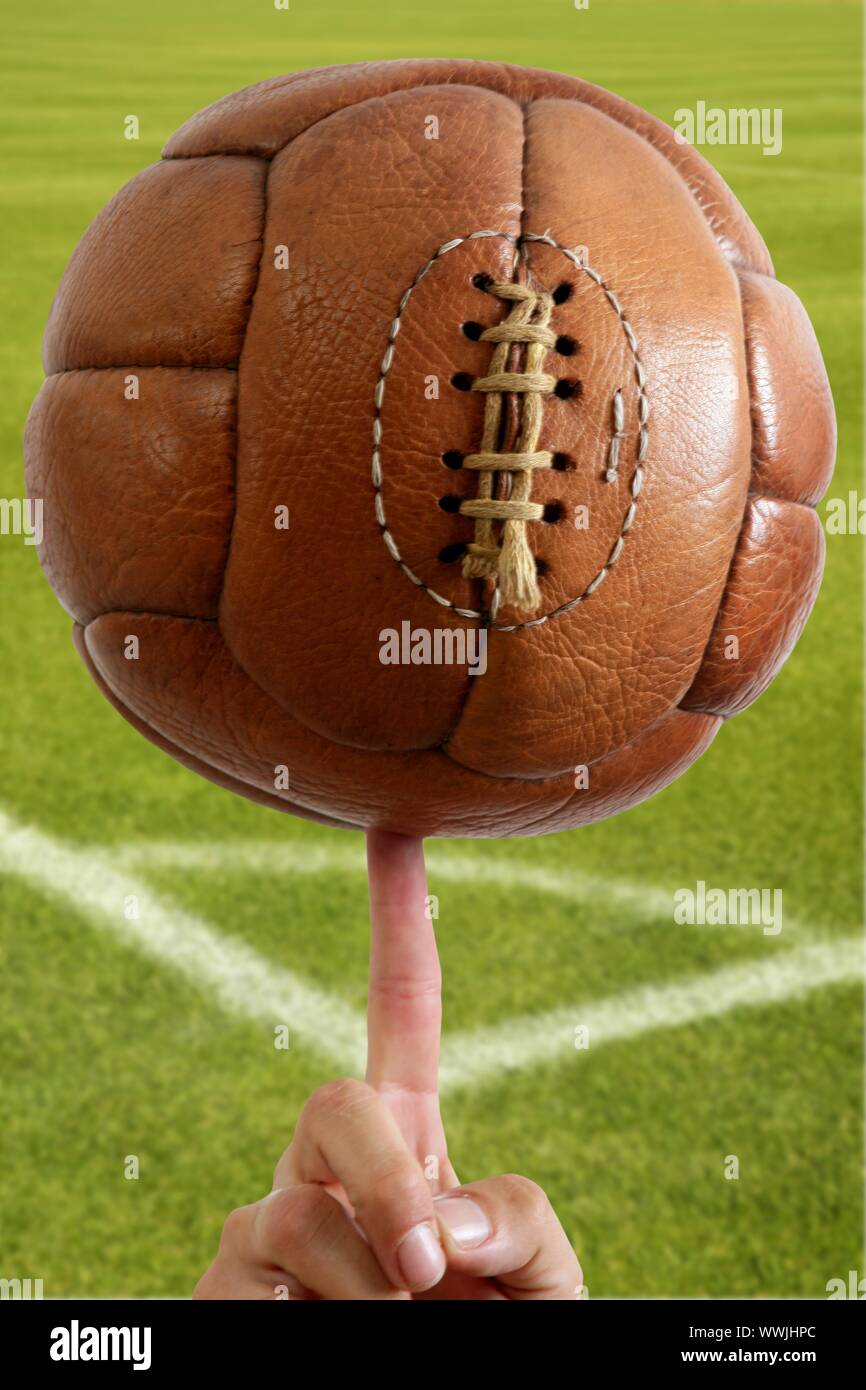 Aged vintage retro football leather ball in man hand grass field Stock ...