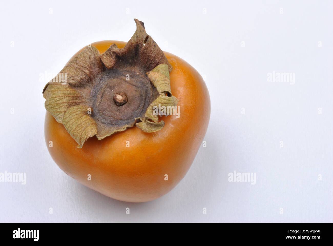 one organic sharon fruit and a white background Stock Photo - Alamy
