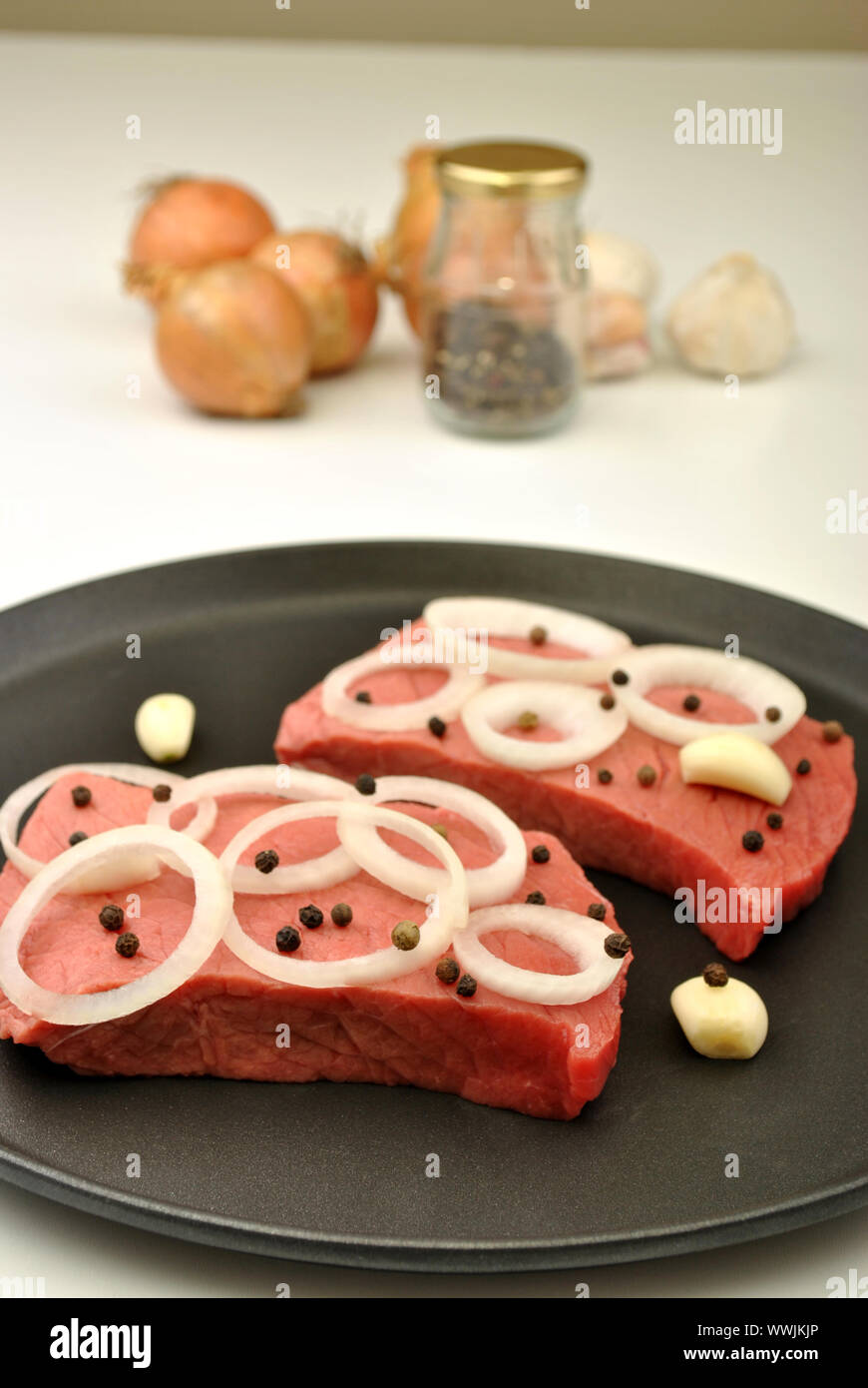 raw organic steak with onion in a pan Stock Photo - Alamy