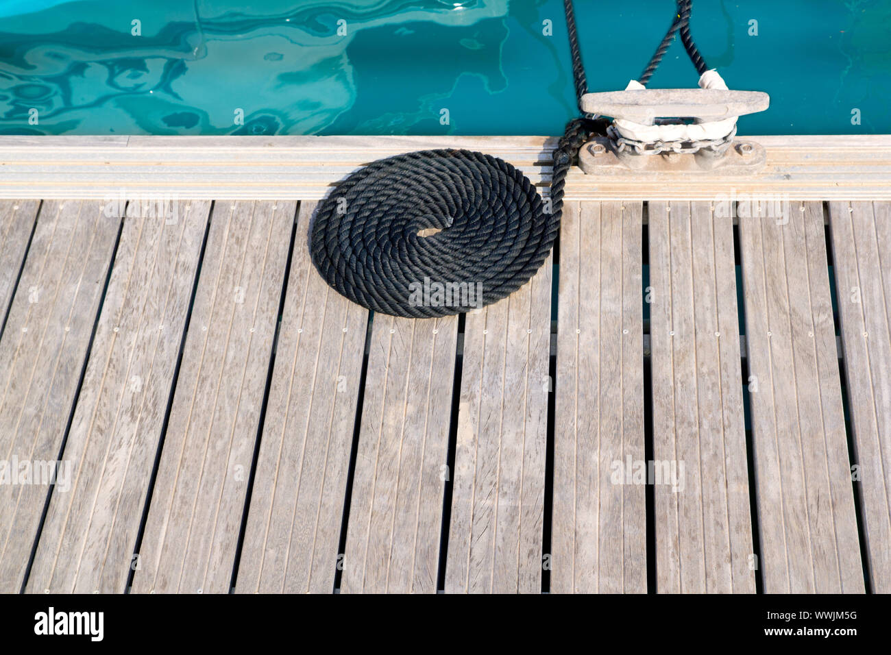 mooring wooden pier with coiled spiral rope and a bitt in marina Stock ...
