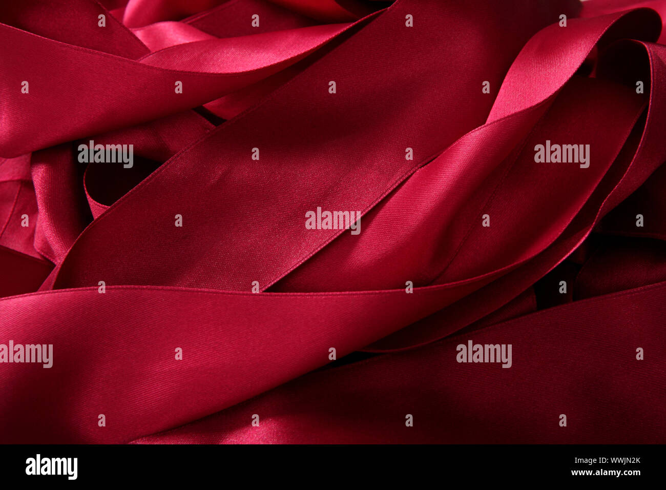 Red satin ribbons in a messy mess texture background Stock Photo - Alamy