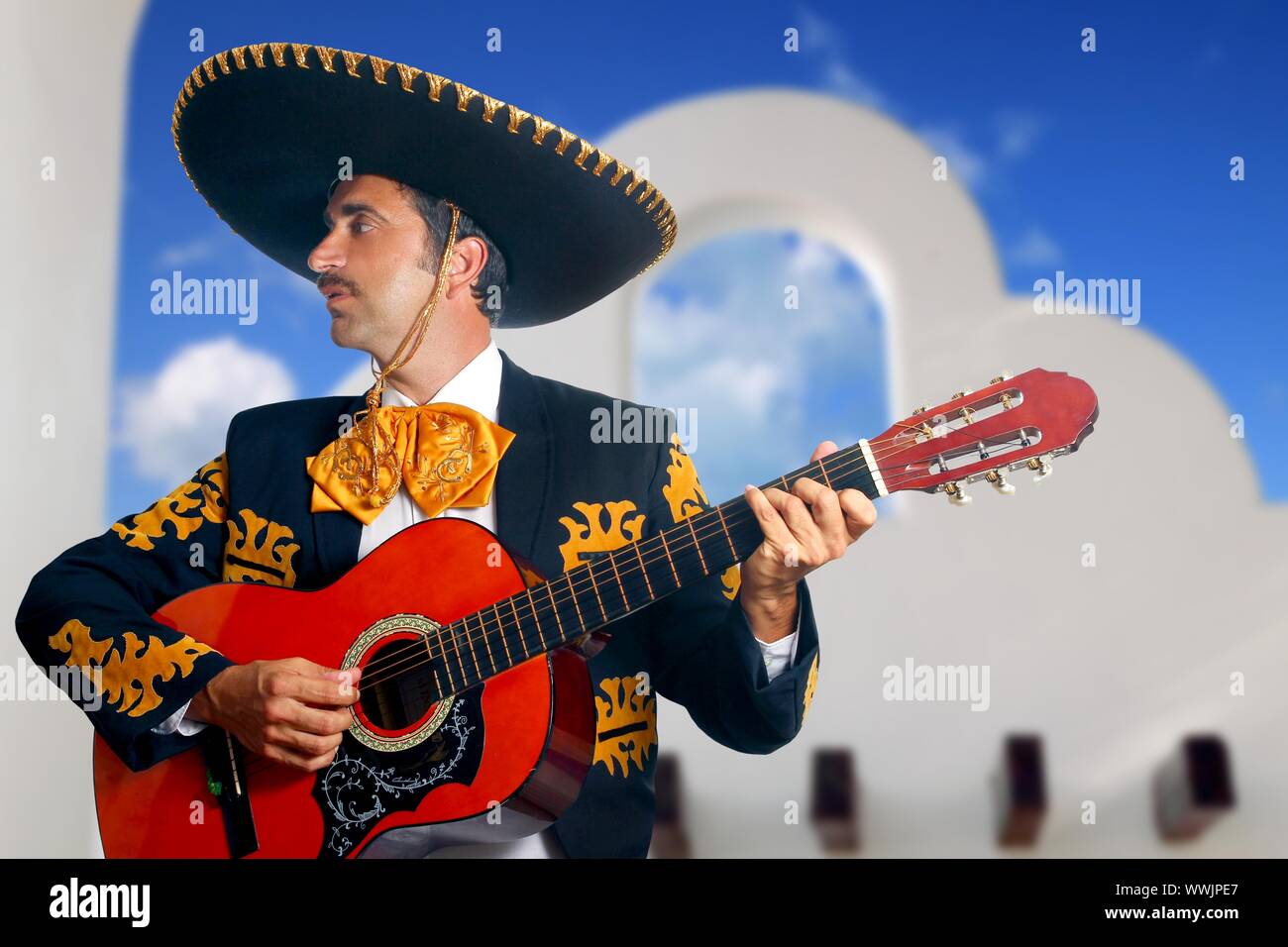Charro Mariachi singer playing guitar in Mexico with white house ...