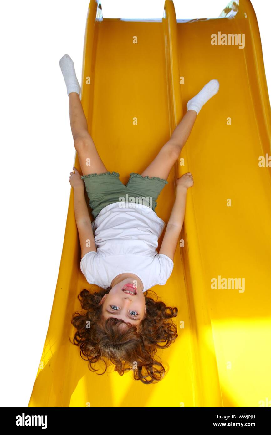 Brunette little girl upside down playground slide isolated on white ...