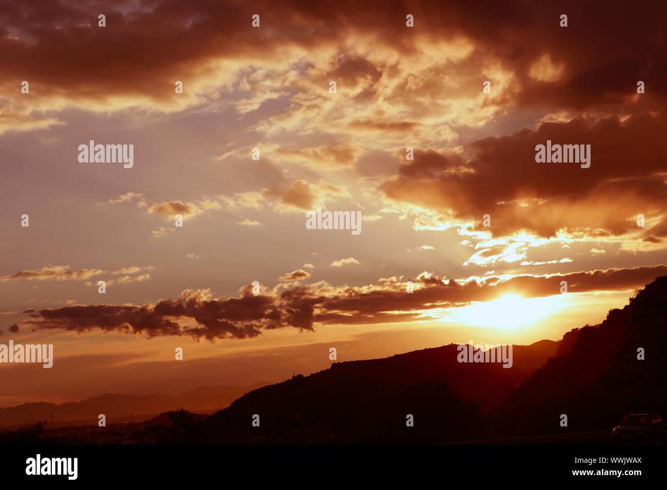 golden orange brown sunset sky clouds with sun Stock Photo - Alamy