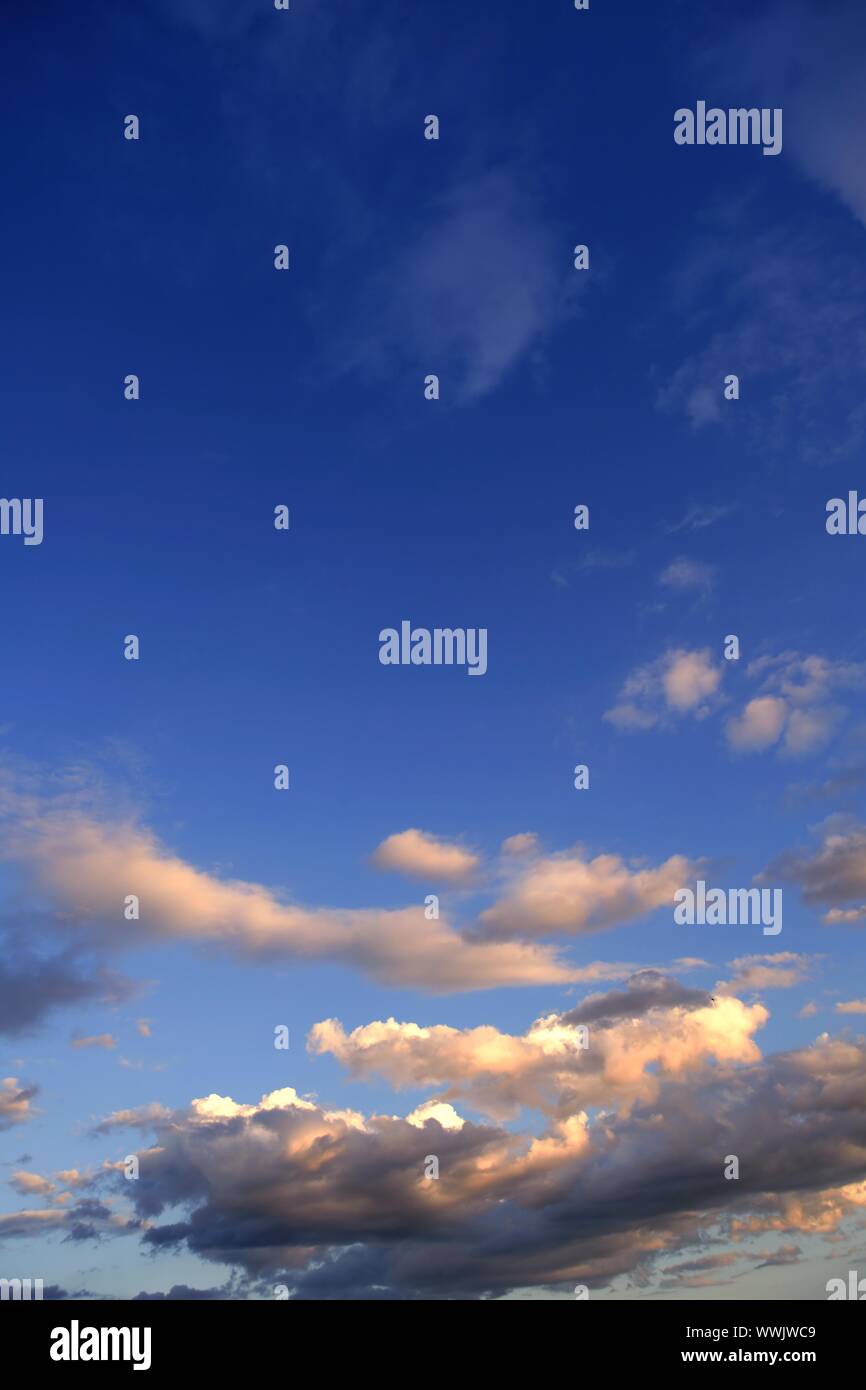 Blue sky background with clouds at sunset Stock Photo - Alamy