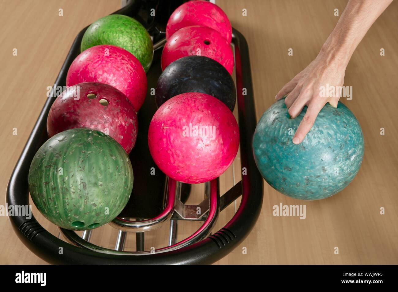 Bowling ball in player man hand in colorful rows Stock Photo - Alamy