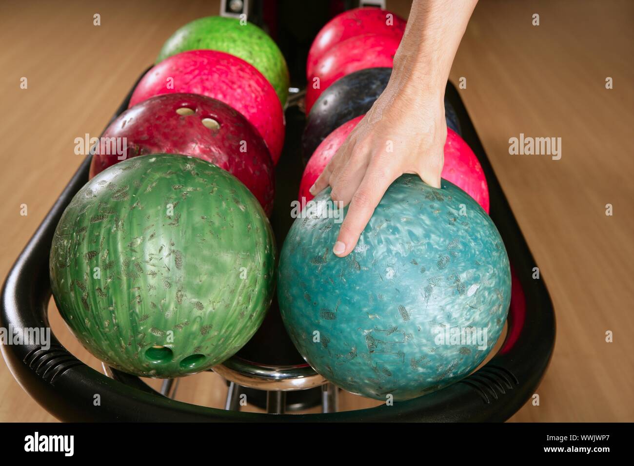 Bowling ball in player man hand in colorful rows Stock Photo - Alamy