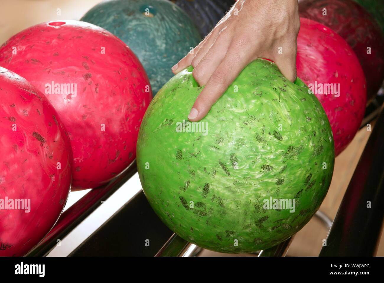 Bowling ball in player man hand in colorful rows Stock Photo - Alamy