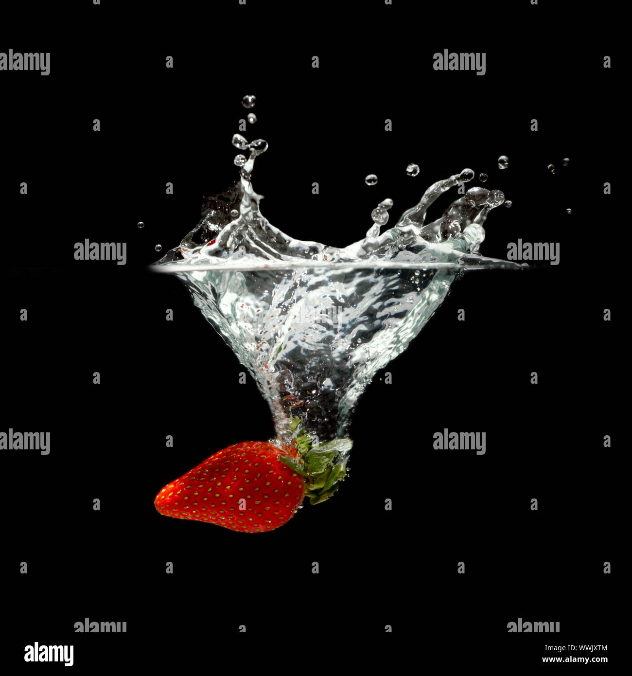 strawberry splashing in water over black background Stock Photo - Alamy