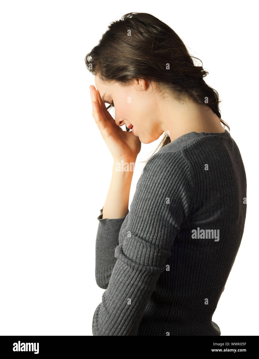 A very sad and depressed woman crying and hiding her face in her hands ...