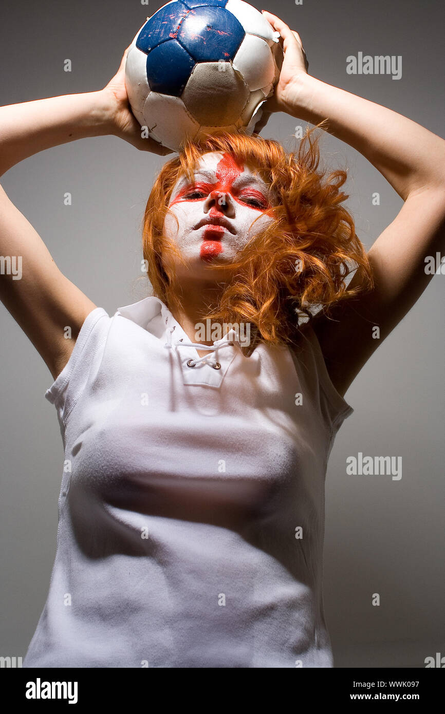 english football makeup girl holding worn soccer ball, looking down ...