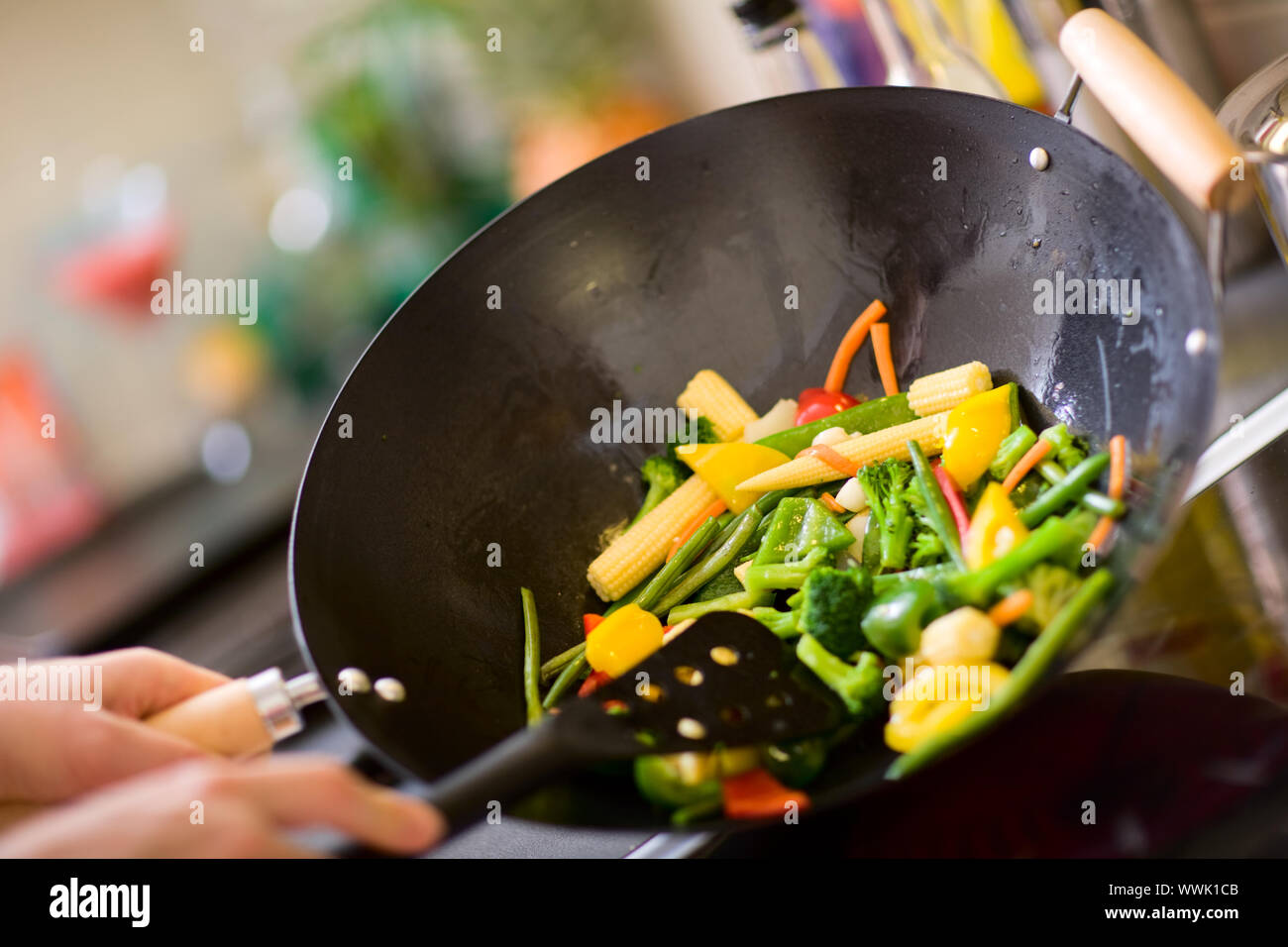 Chef cooking vegetables in wok pan Stock Photo - Alamy