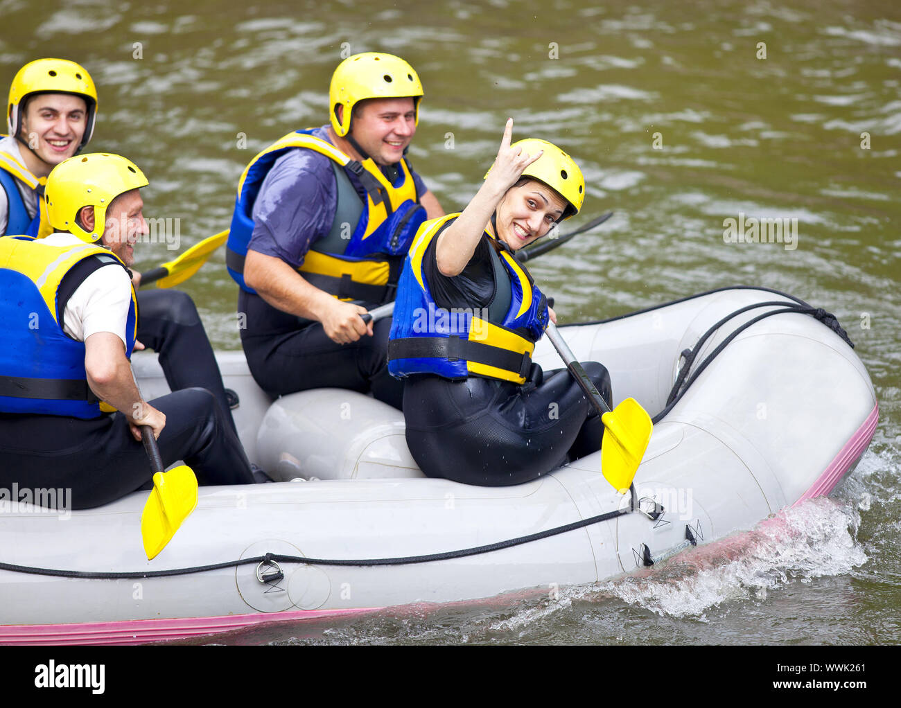 Group of four happy people sitting on a boat, woman showing rock on ...