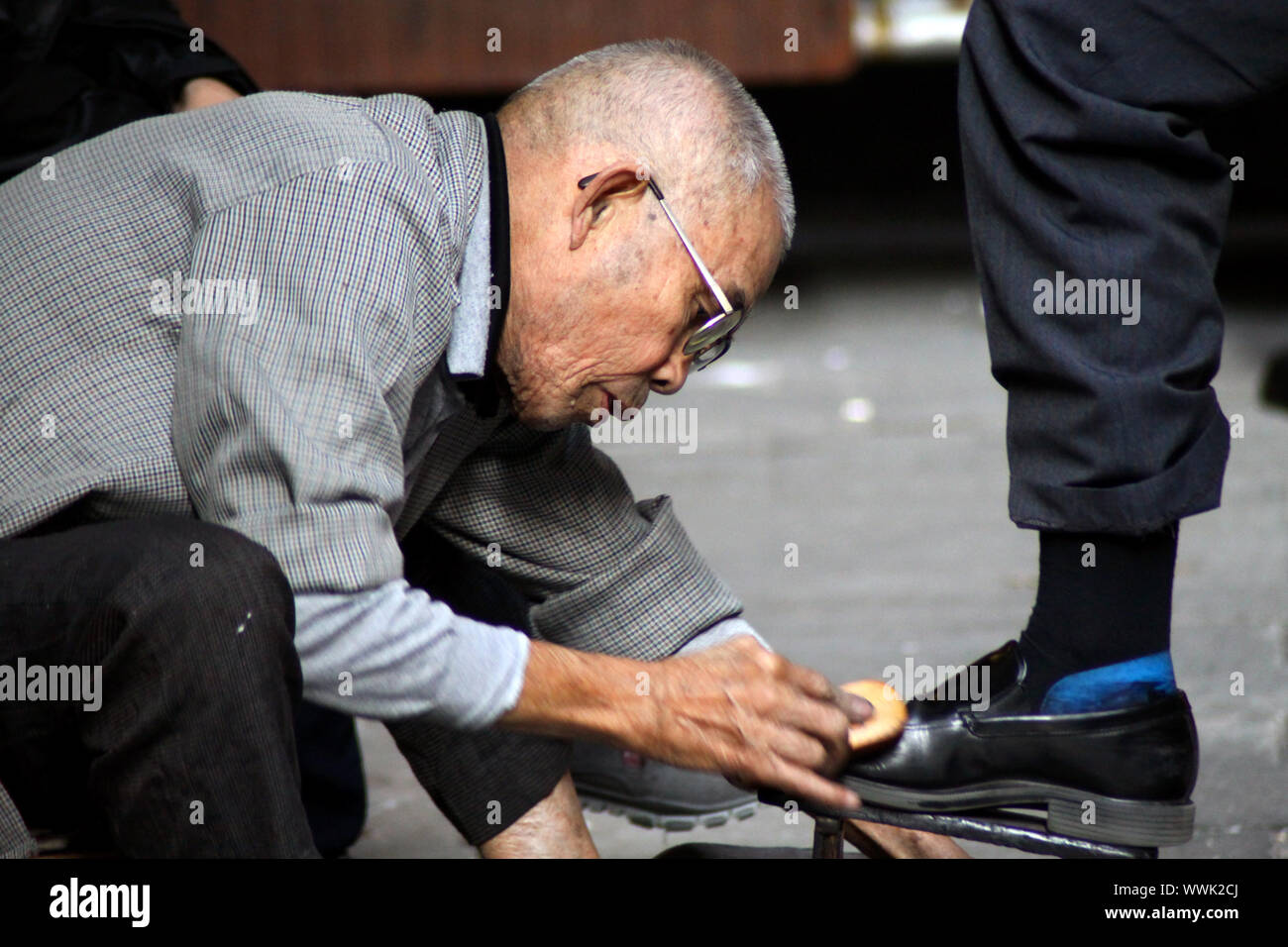 Hong Kong people works as shoes cleaners Stock Photo - Alamy