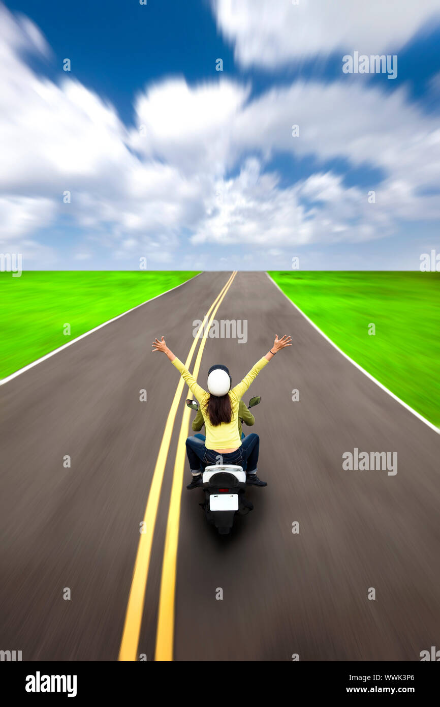 Happy couple riding scooter on the freeway Stock Photo - Alamy