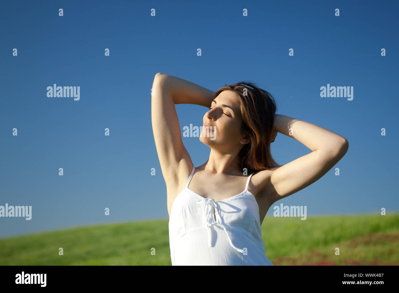 Beautiful young woman relaxing on the field Stock Photo - Alamy