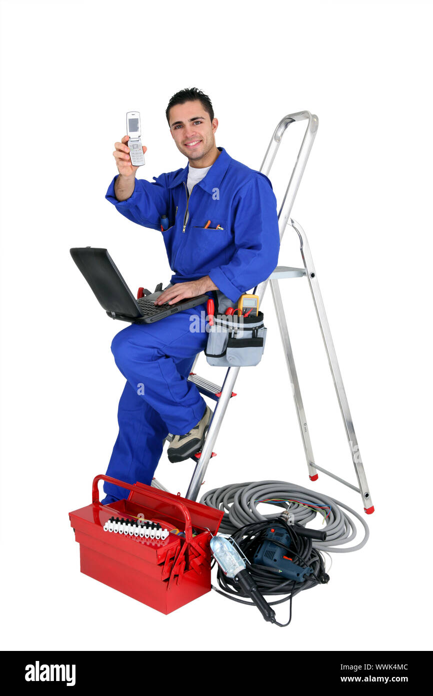 Technician with laptop and cellphone leaning on a ladder Stock Photo ...