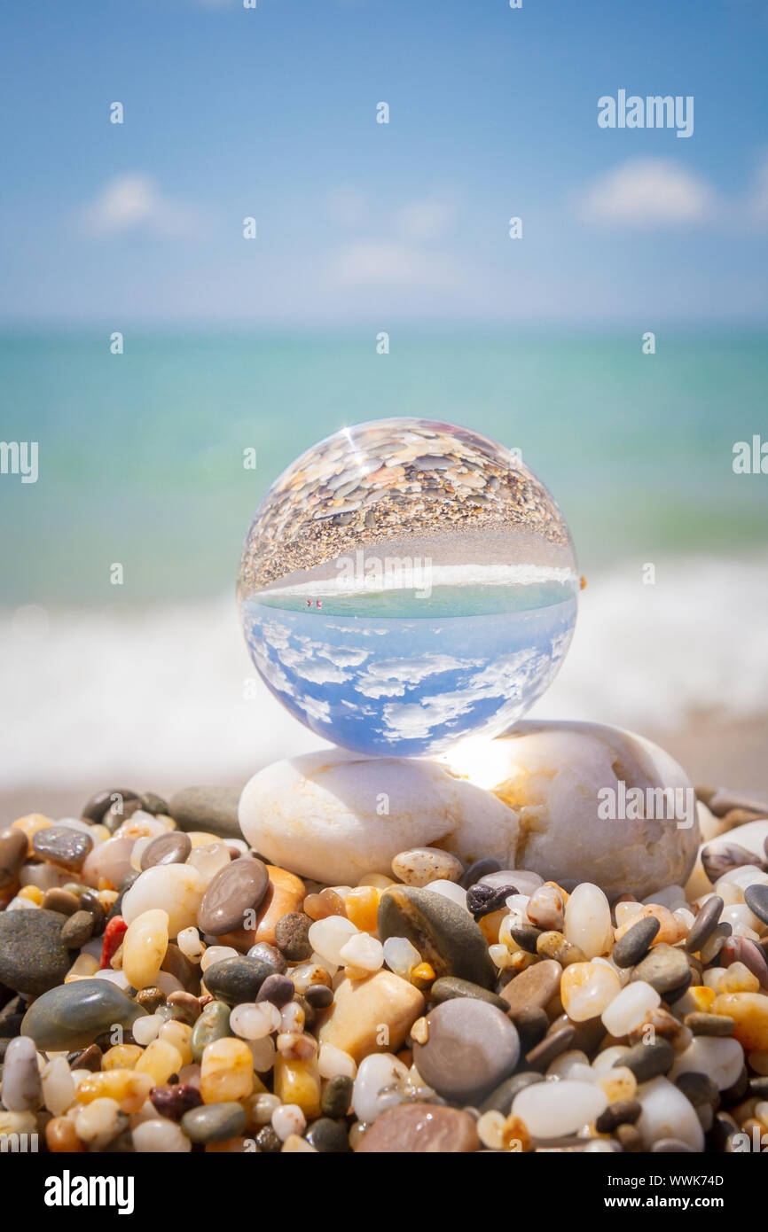 Glass round ball on the beach reflects the sea in summer Stock Photo ...