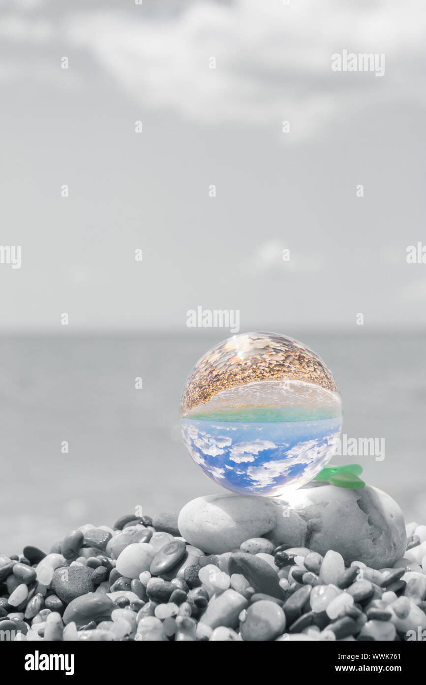 Glass round ball on the beach reflects the sea in summer Stock Photo ...