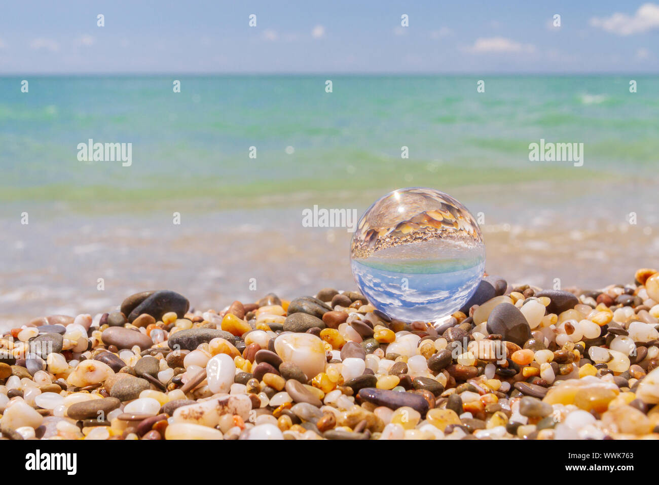 Glass round ball on the beach reflects the sea in summer Stock Photo ...