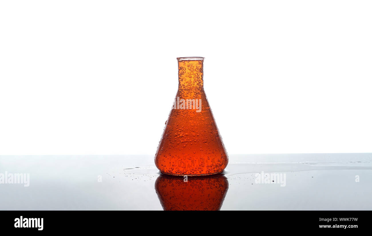 Laboratory Glass with orange liquid Stock Photo - Alamy