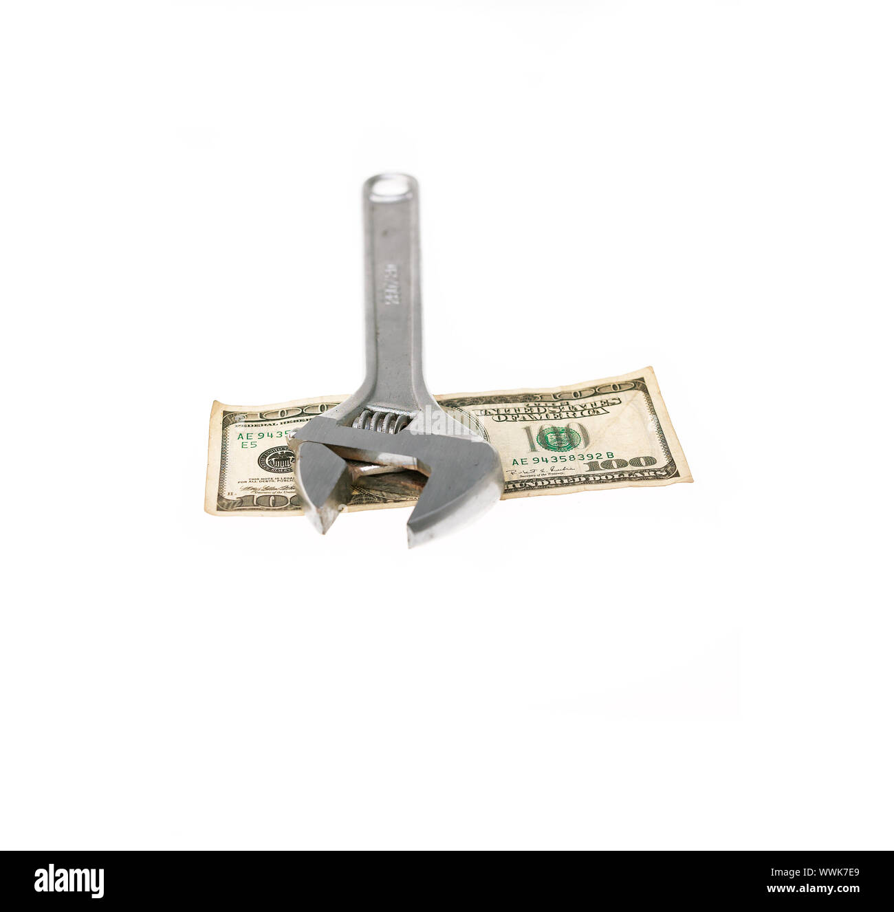 wrench tool fixing dollar bill isolated on white background closeup ...