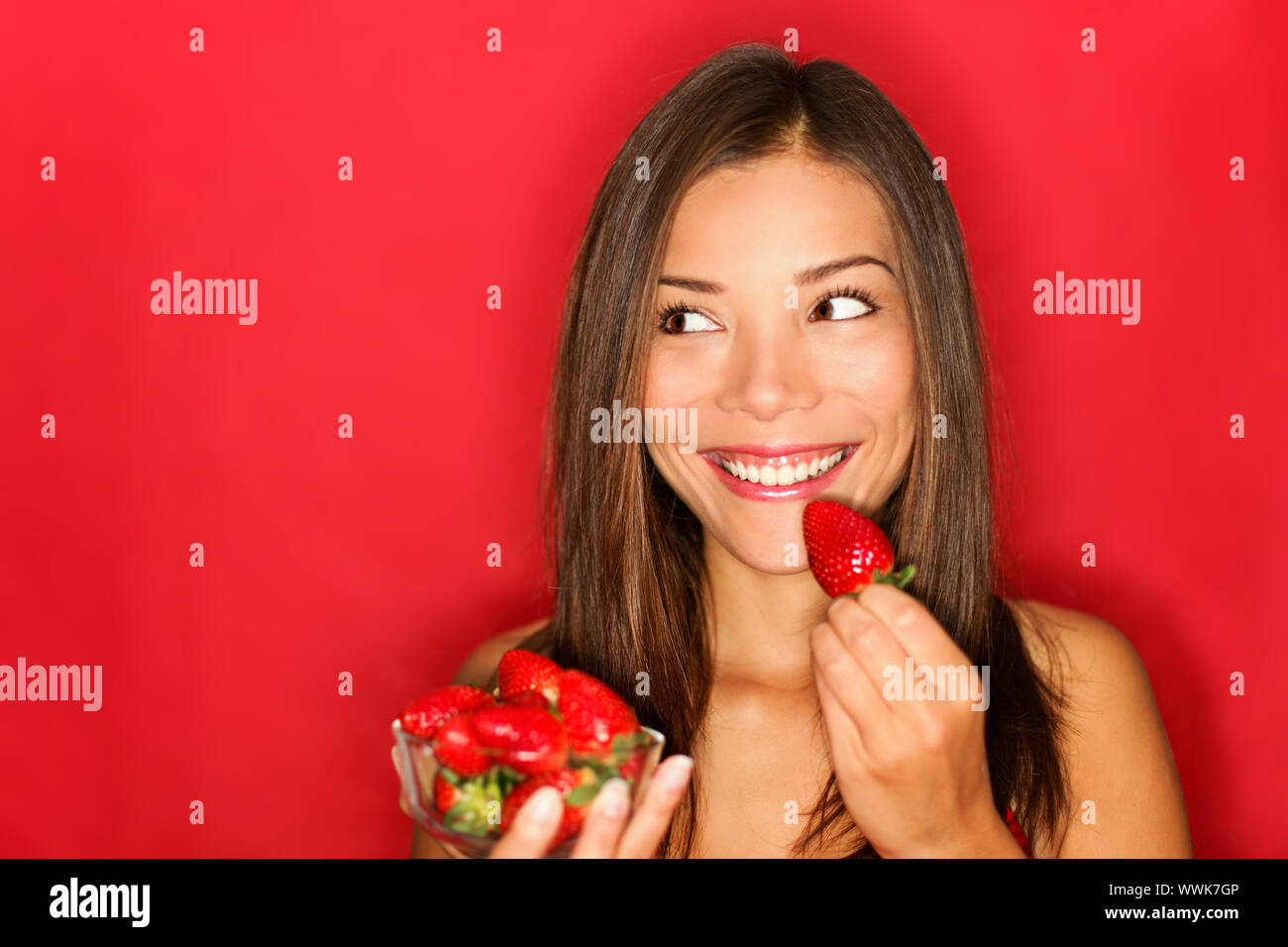 Girl eating strawberries Stock Photo - Alamy