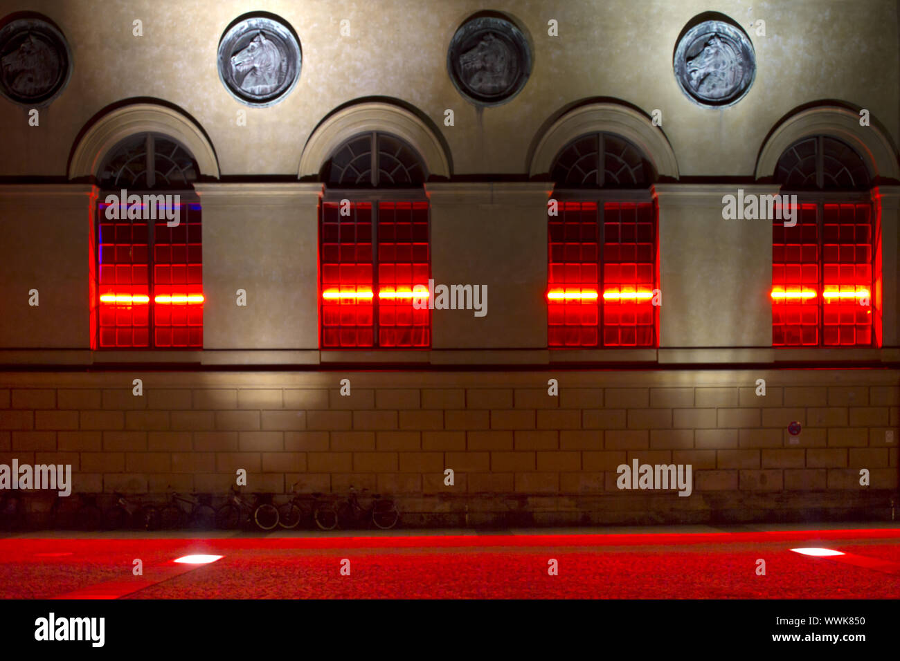 Red illuminated windows on historical house facade Stock Photo - Alamy