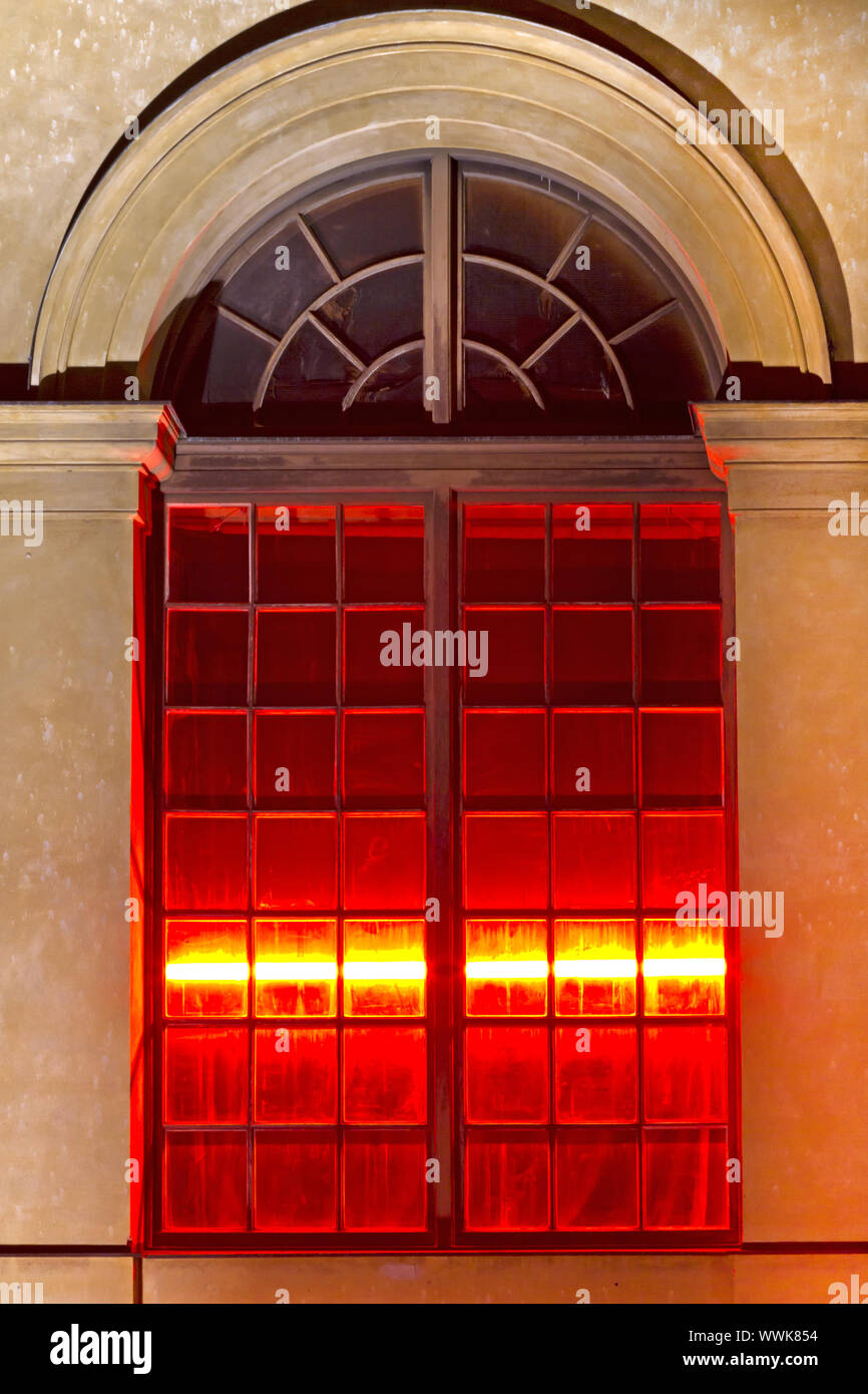 Red illuminated window on historical house facade Stock Photo - Alamy