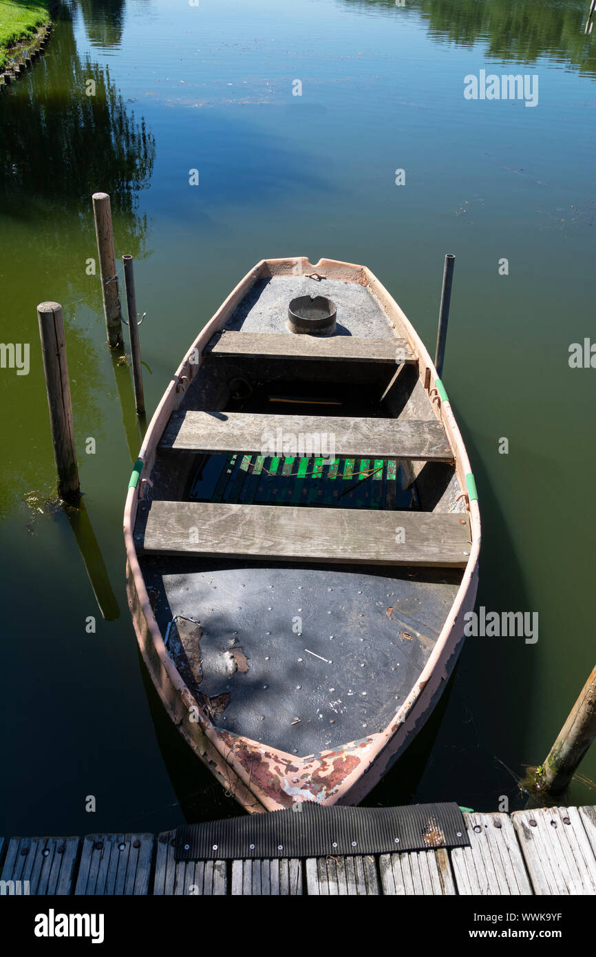 Old rowing boat is on the side of the green water Stock Photo - Alamy