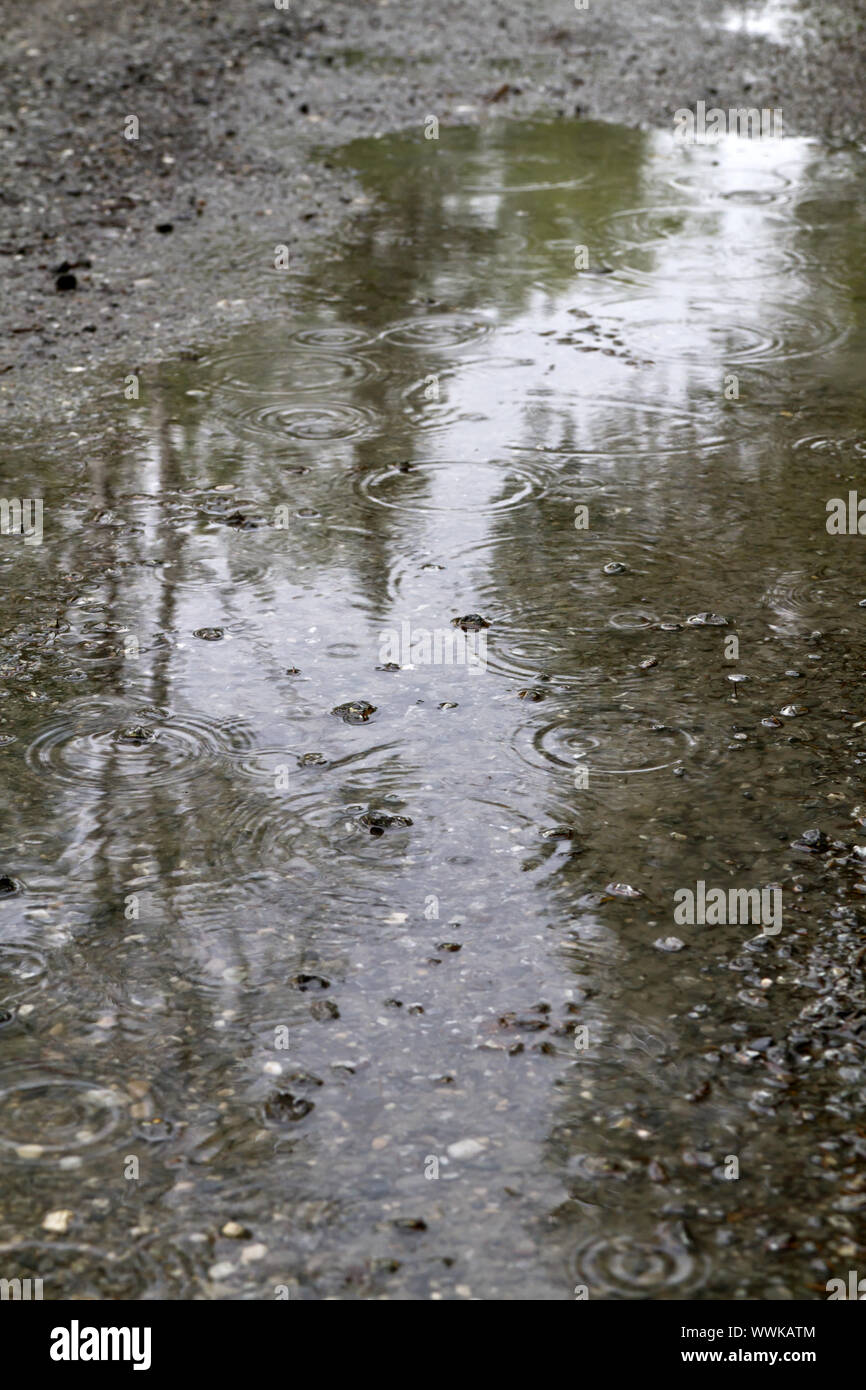 Rain drops rippling in puddle hi-res stock photography and images - Alamy