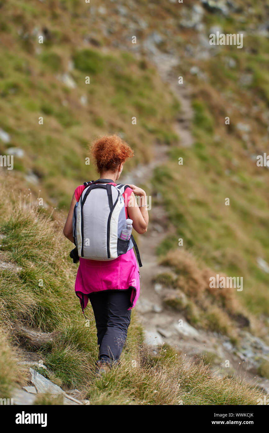 Backpacker lady with camera hiking on a mountain trail Stock Photo - Alamy