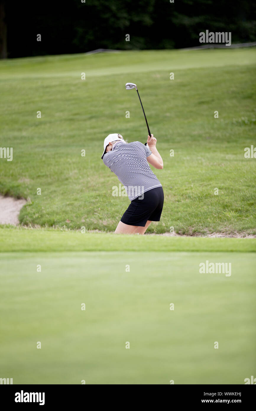 Woman playing golf on a golf course Stock Photo - Alamy