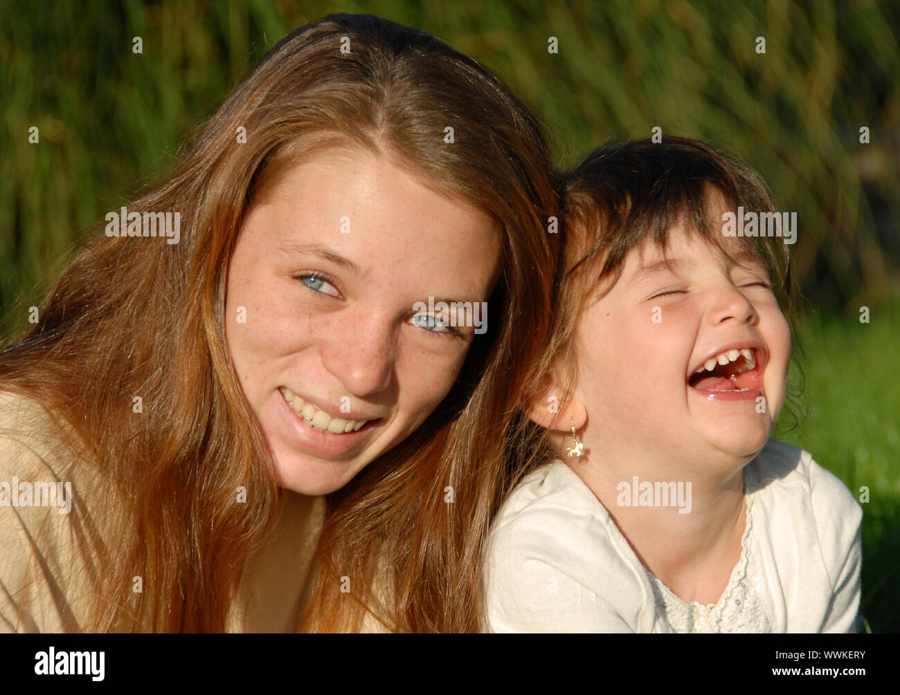 two smiling sisters: teenager and little girl Stock Photo - Alamy
