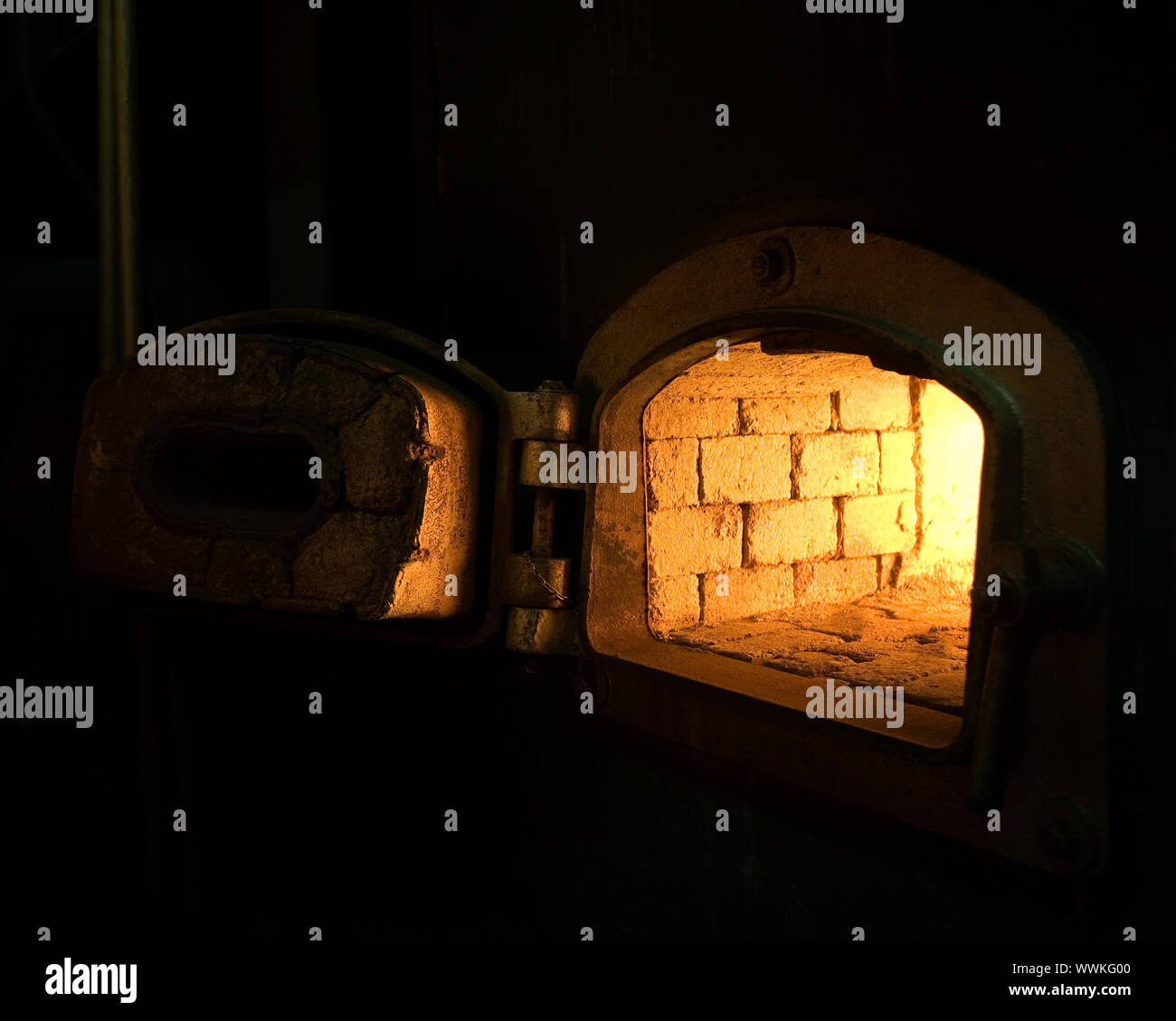Burning Brick Wall stove in dark environment Stock Photo - Alamy