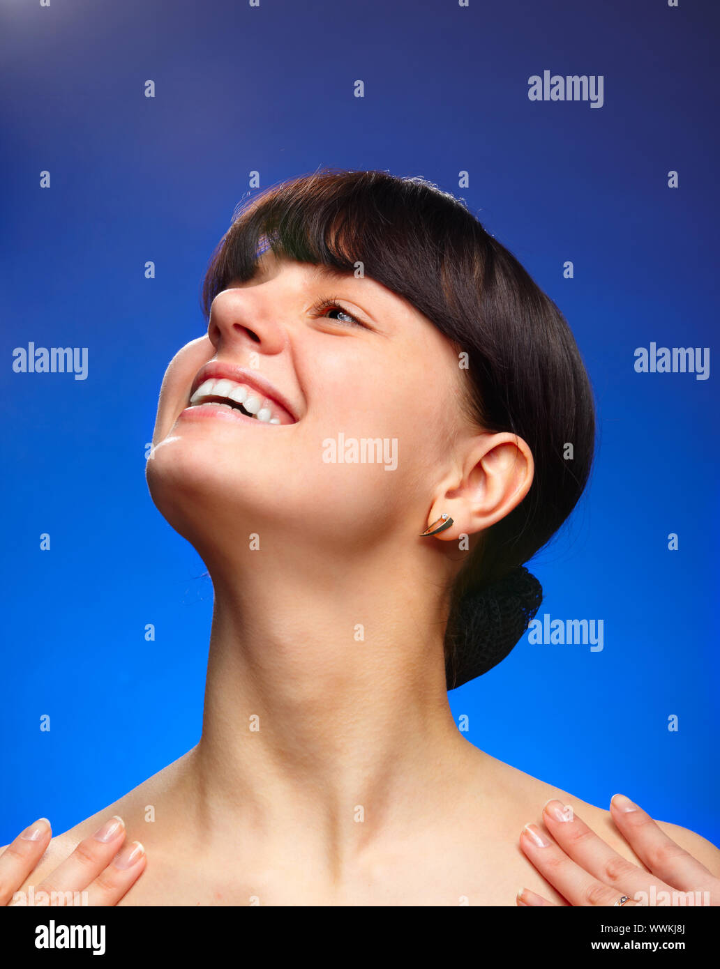 portrait of beautiful young smiling model posing on blue Stock Photo ...