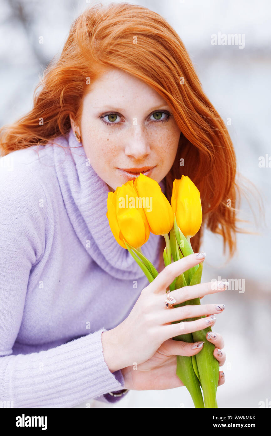 Beautiful woman smelling spring flowers Stock Photo - Alamy