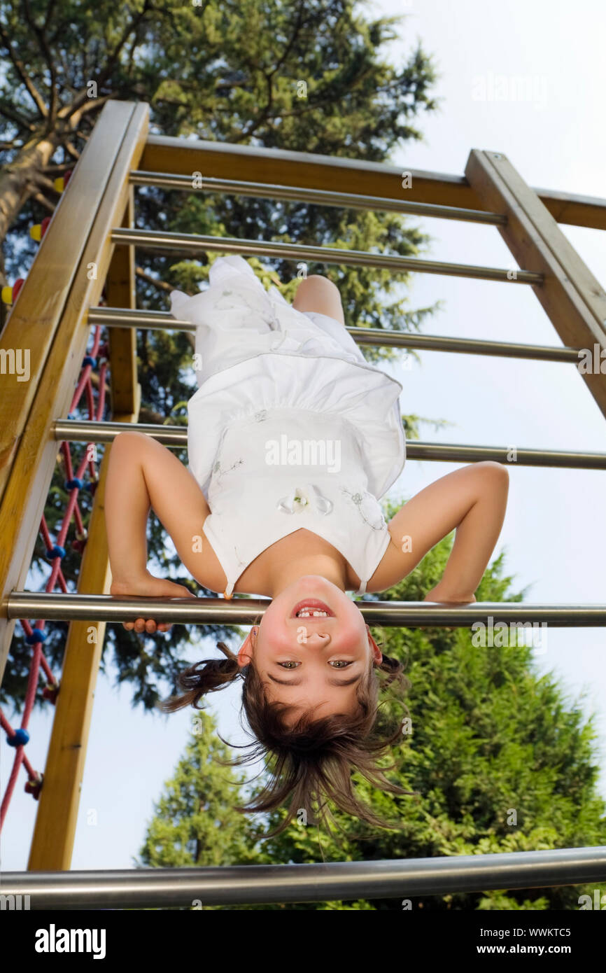 Girl hanging upside down on jungle gym hi-res stock photography and images - Alamy