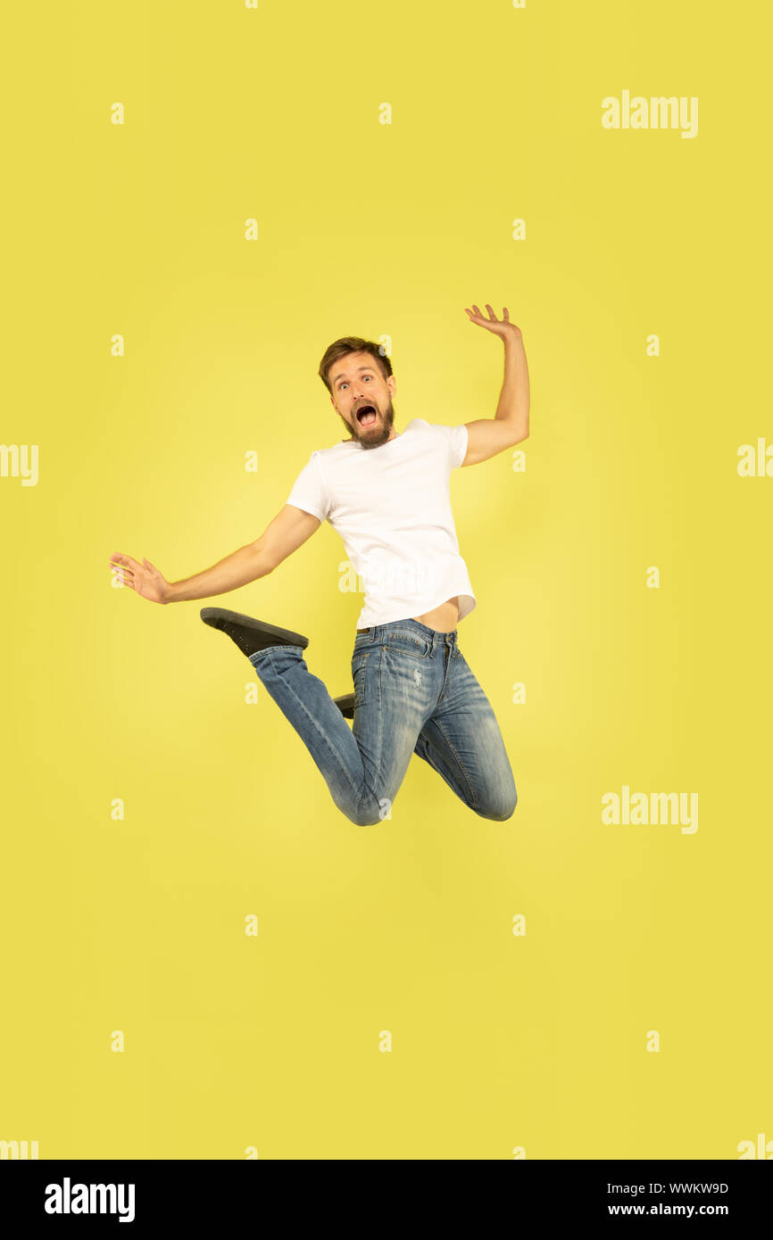 Full length portrait of happy jumping man isolated on yellow background ...