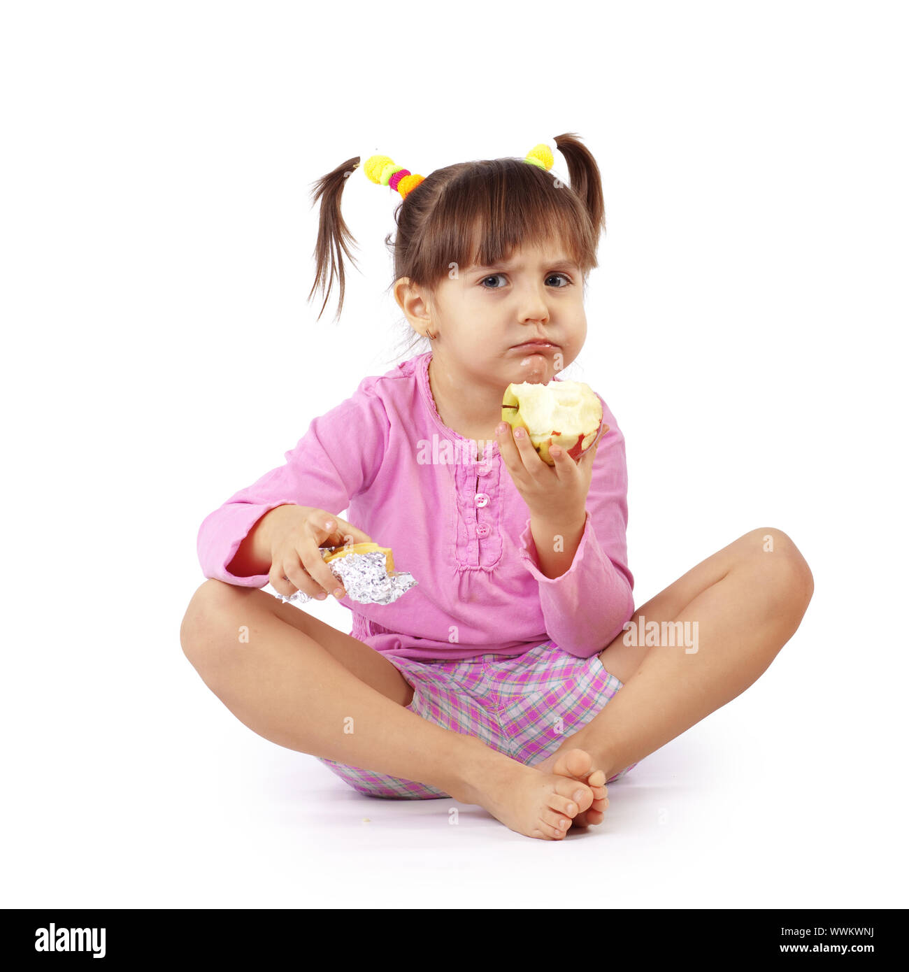 Portrait of funny kid girl eating apple over white Stock Photo - Alamy