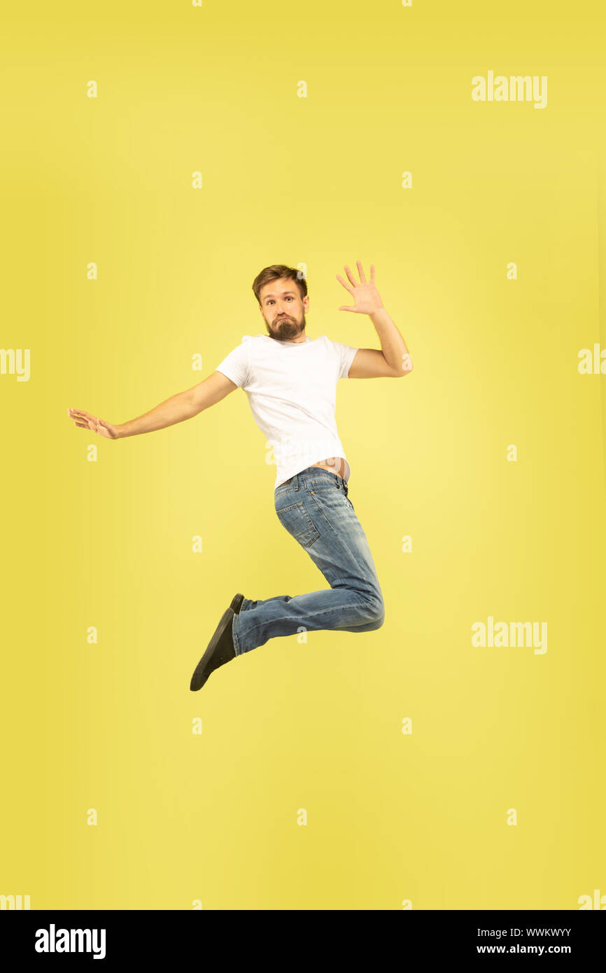 Full length portrait of happy jumping man isolated on yellow background ...