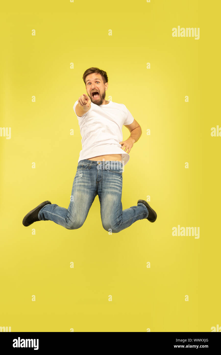 Full length portrait of happy jumping man isolated on yellow background ...