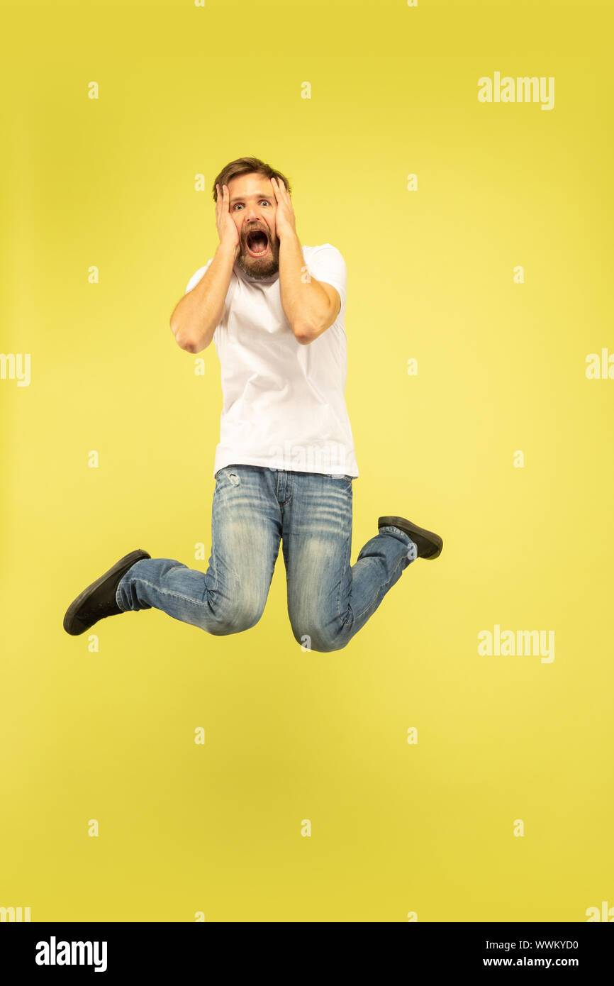 Full length portrait of happy jumping man isolated on yellow background ...